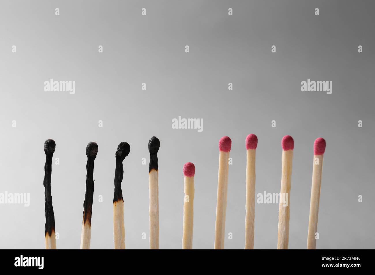 Burnt and whole matches on light grey background, closeup. Stop ...