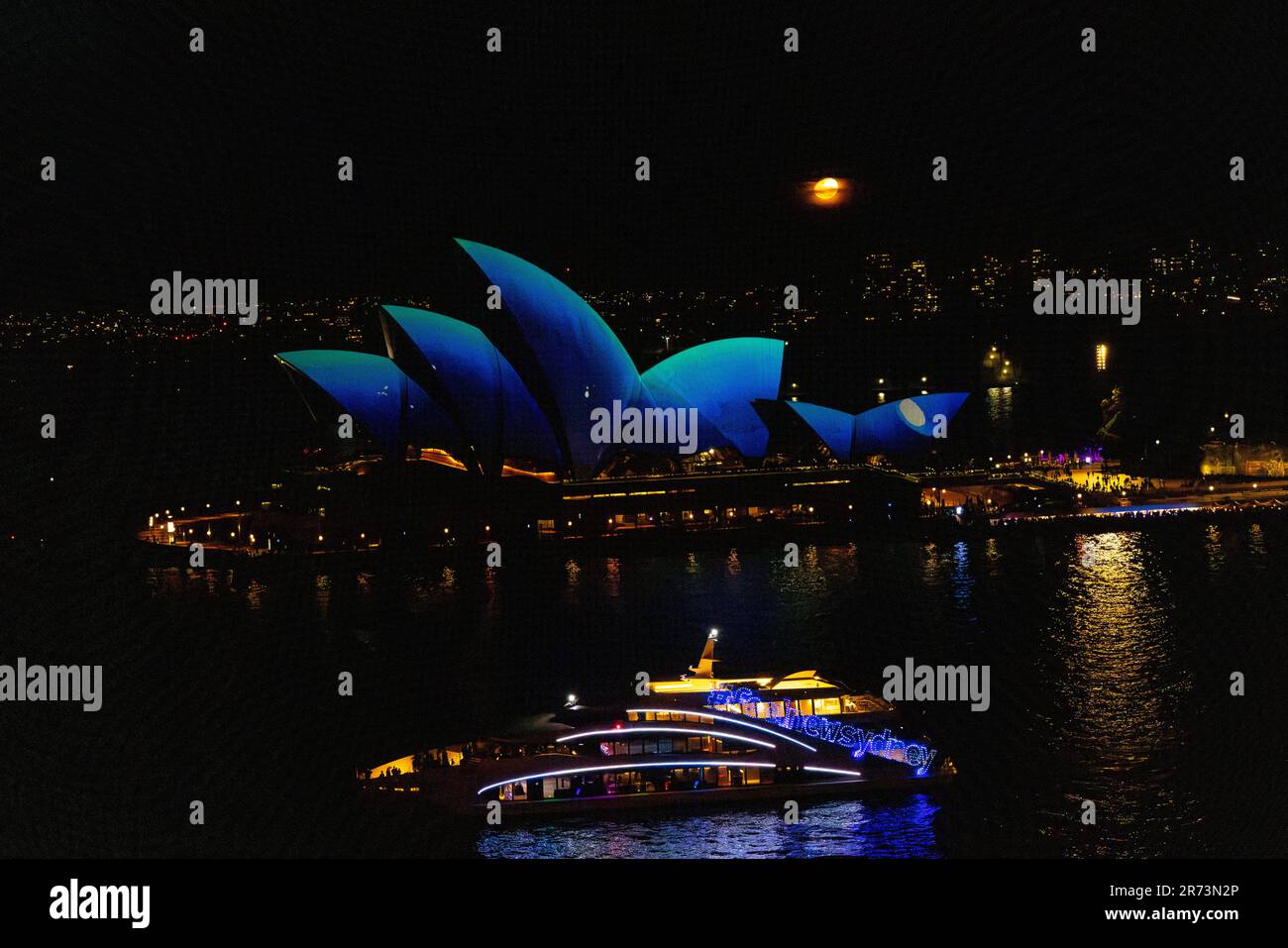 VIVID Sydney 2023. Lighting of the sails of the Opera House, Sydney Harbour. Moon rising above ...