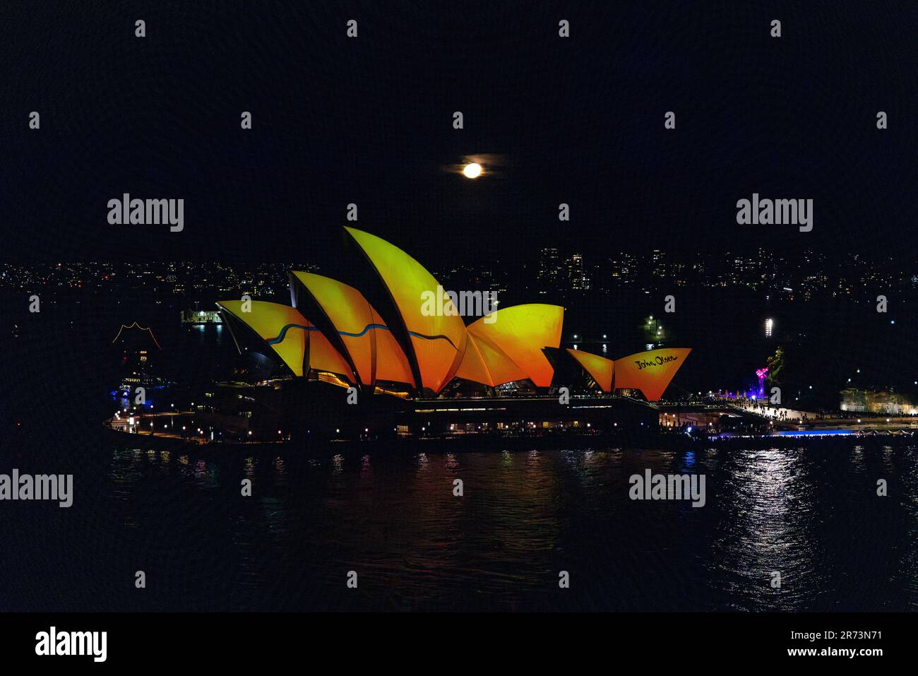VIVID Sydney 2023. Lighting of the sails of the Opera House, Sydney Harbour. Moon rising above ...