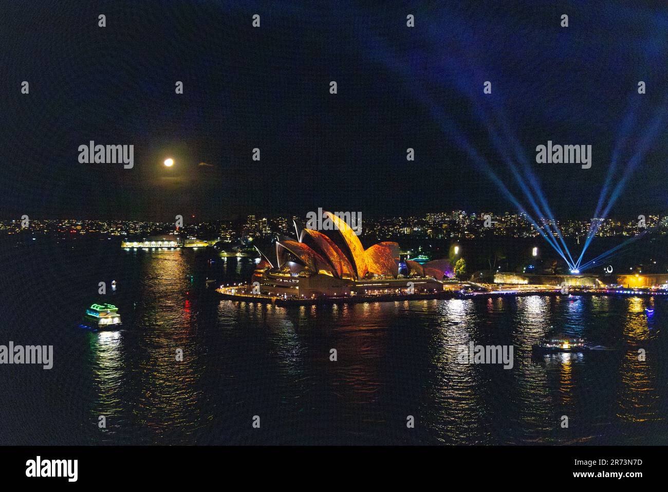 VIVID Sydney 2023. Lighting of the sails, Sydney Harbour. Moon rising above the Opera House ...