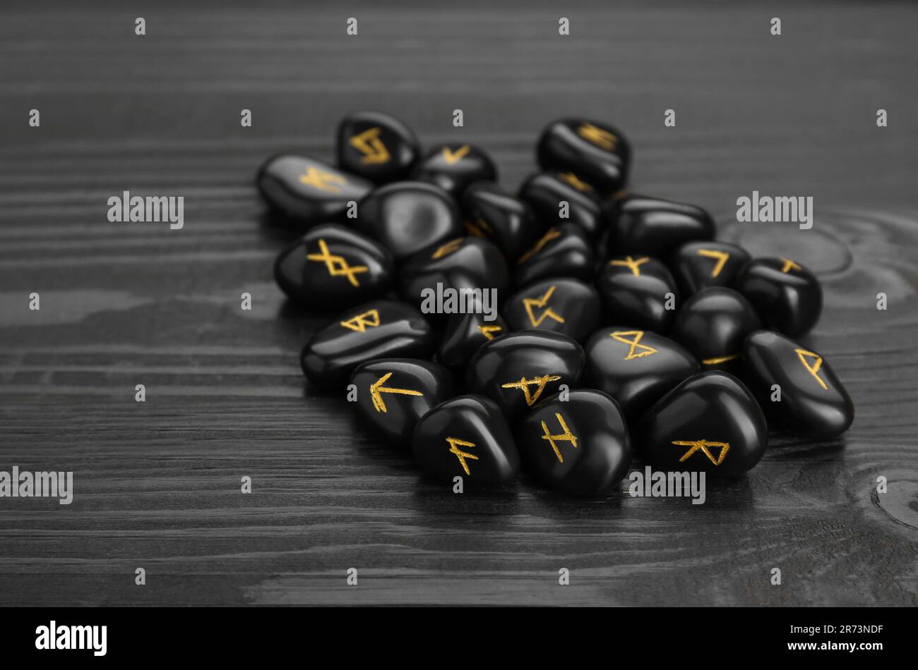 Pile of rune stones on black wooden table Stock Photo - Alamy