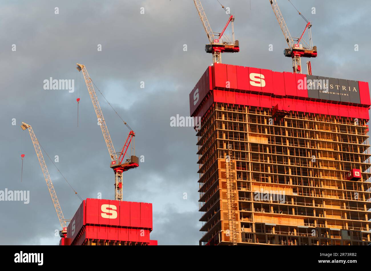 Cranes on top of a new large condo project under construction in ...