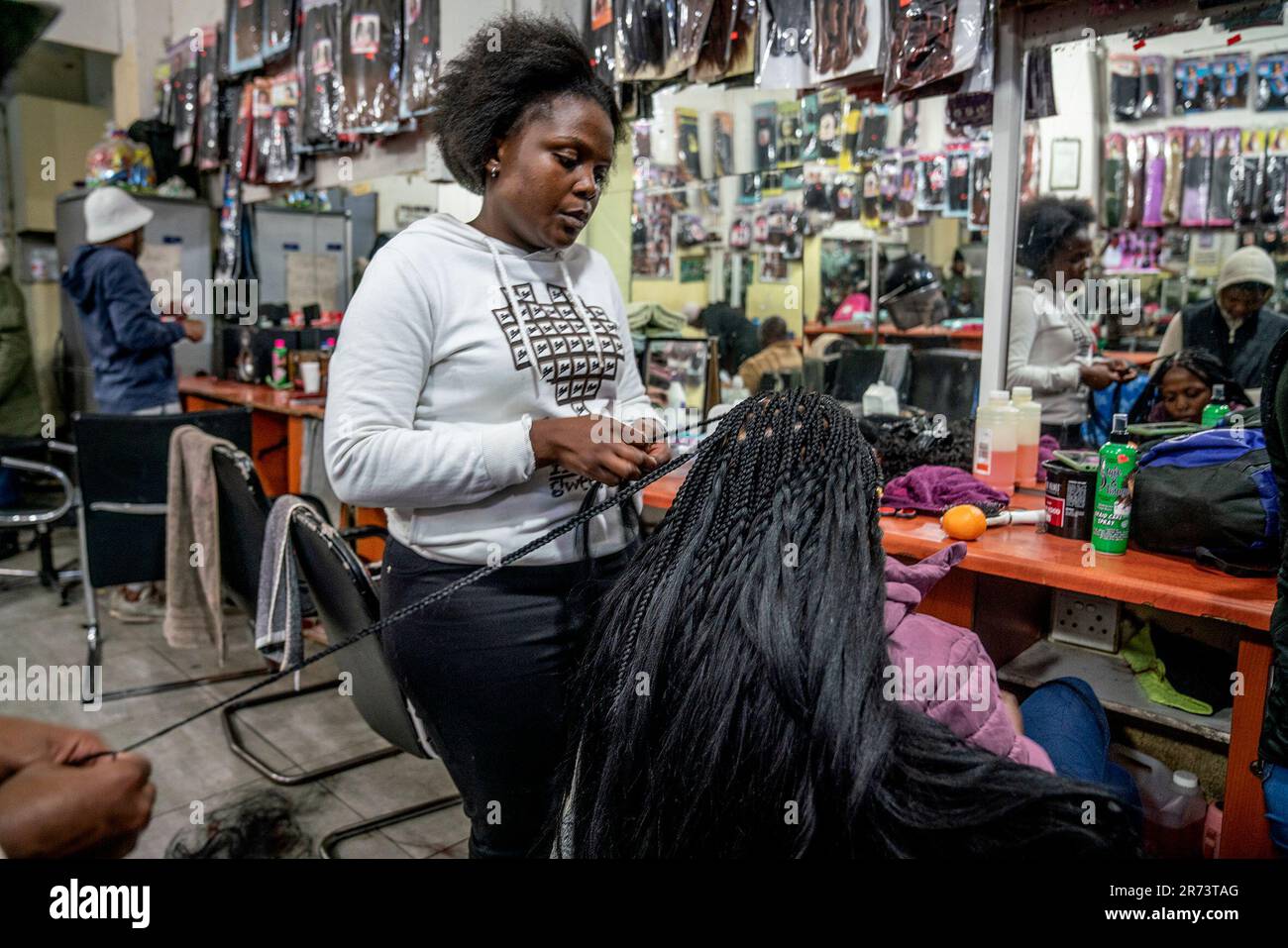 Johannesburg, South Africa. 12th June, 2023. A hairdresser braids the ...
