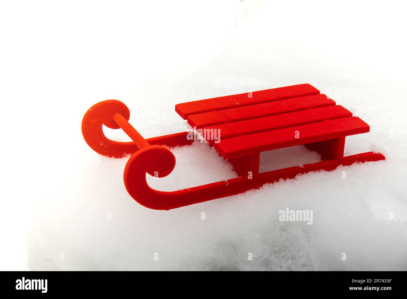 Small Red sled on snow background in beautiful winter day. Copy space ...