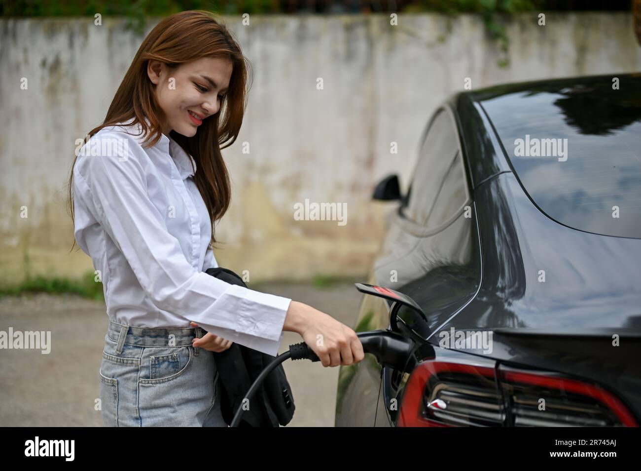 Chiang Mai, Thailand - Jun 12 2023: An attractive Asian woman charging ...