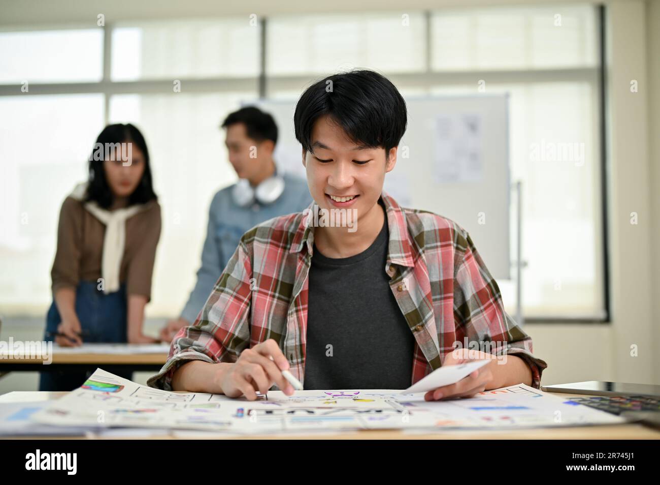 A happy and smart young Asian male graphic designer or UI, UX developer ...