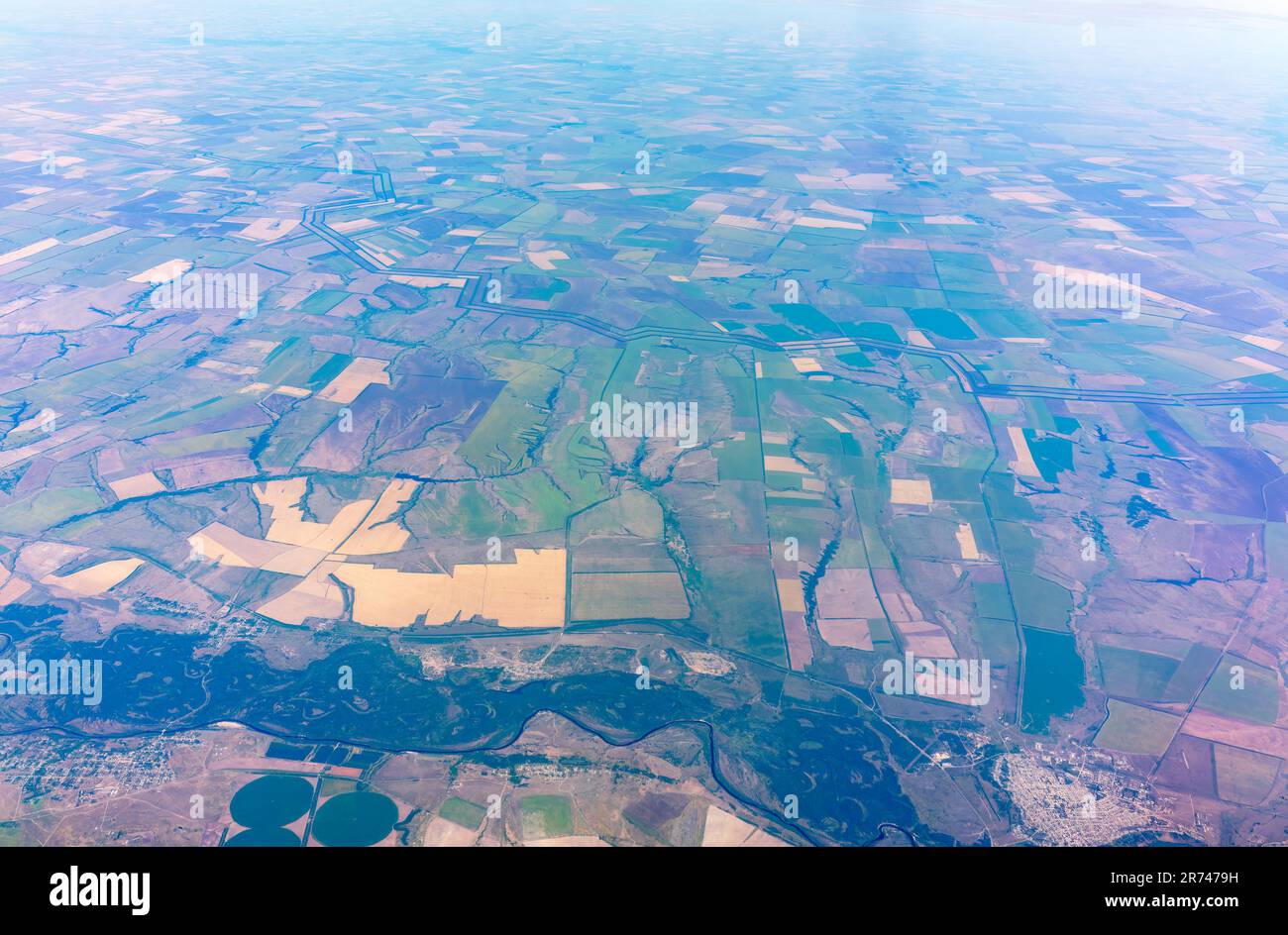 Aerial view from airplane window above green ground. View from the ...
