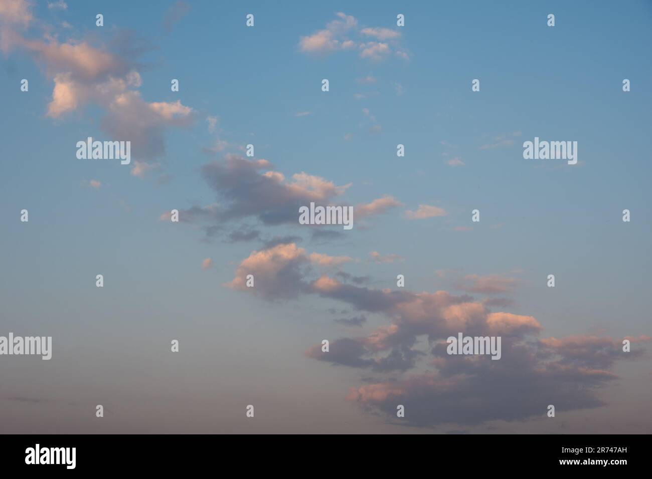 sunset sky with pink clouds, diagonally stripe, grey above. Whispy pink clouds and blue sky ...