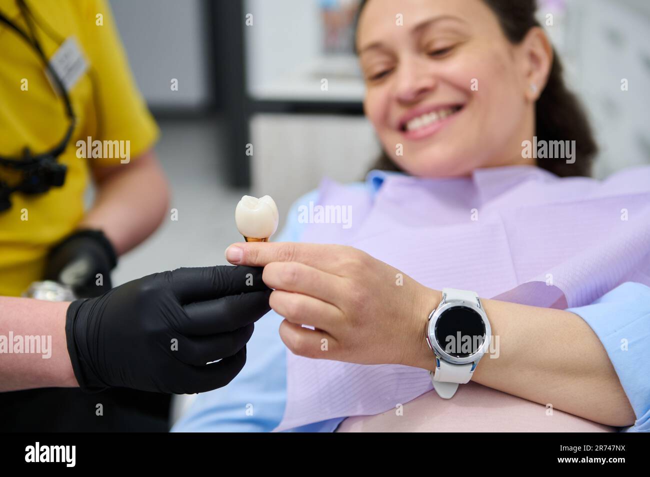Focus on veneer dental implant sample, in hands of orthodontist dentist ...