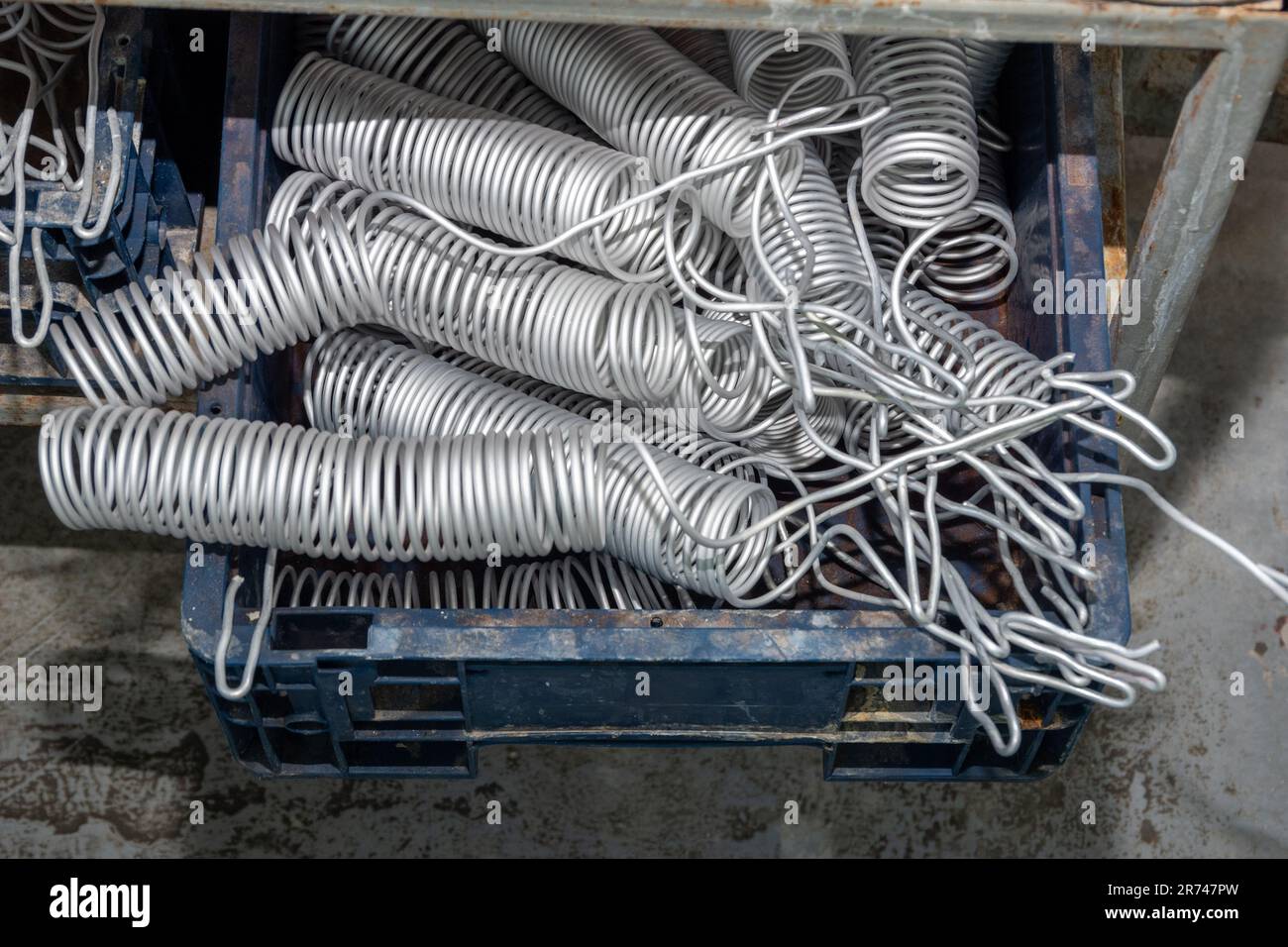 Gray wires twisted into a spiral, springs in a box. Production, storage ...