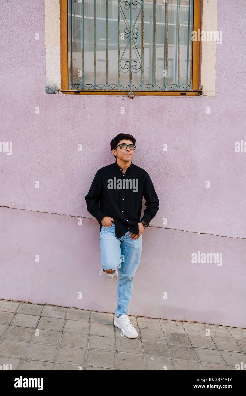 Young transgender man leaning on a wall while posing outdoors on the ...