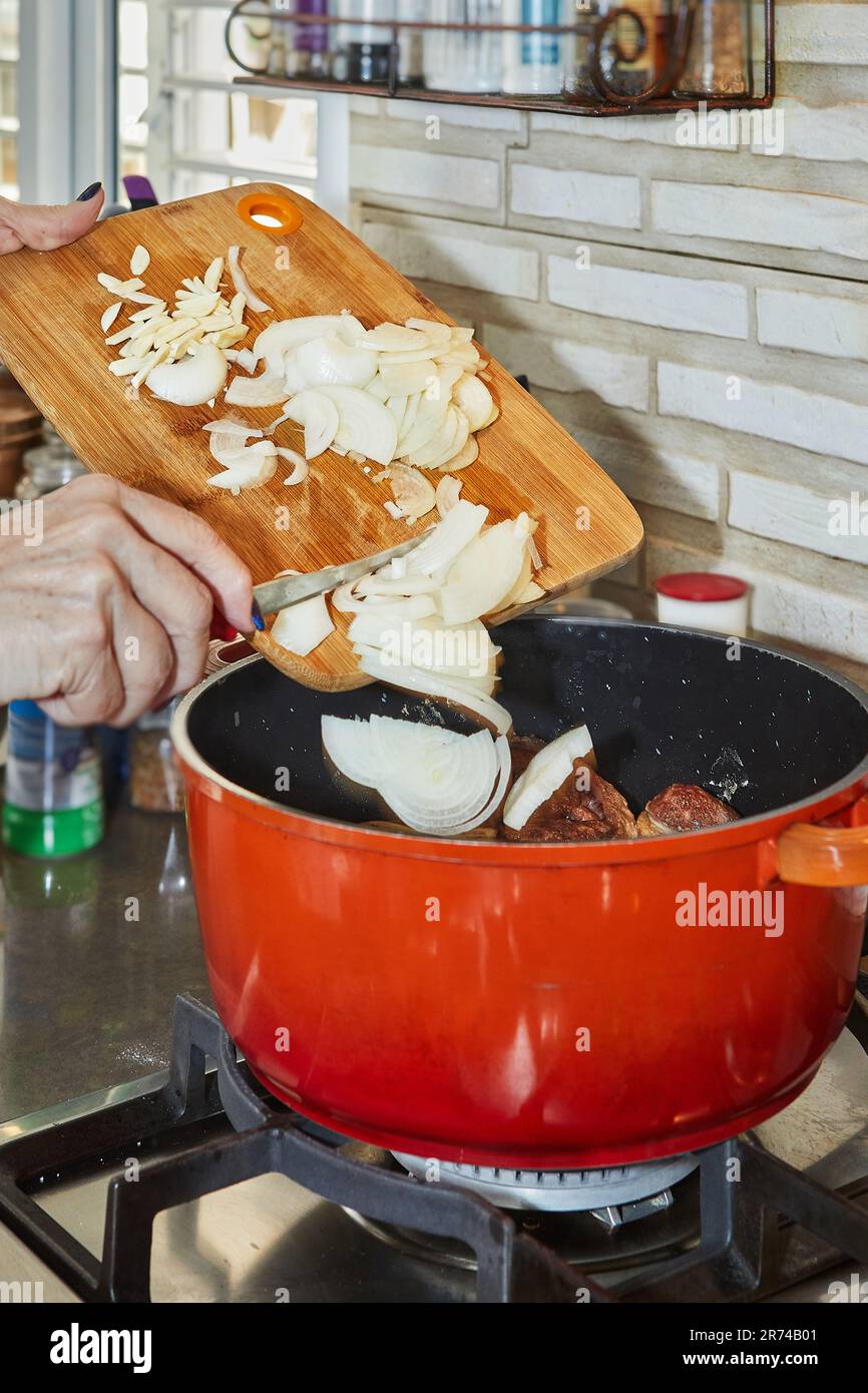 Chef adds finely chopped onion to the pot with the ingredients on the ...