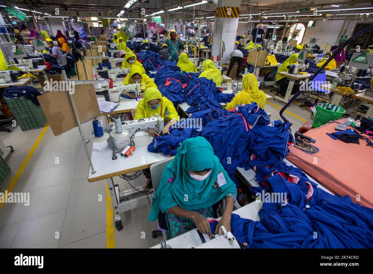 Ready-made garments (RMG) workers working in a factory at Fatullah in Narayanganj, Bangladesh ...