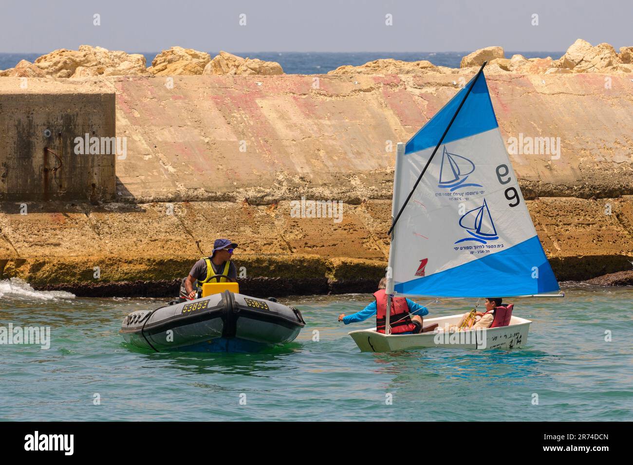 Instructor in a rubber dinghy explains the basics of sailing to ...