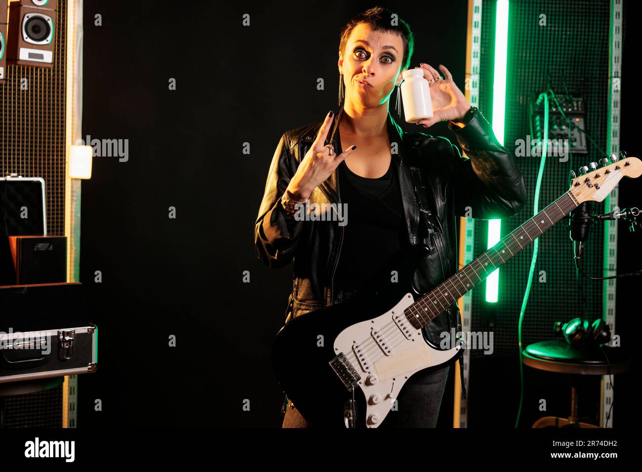 Rock performer holding bottle of drugs pointing at health care product ...