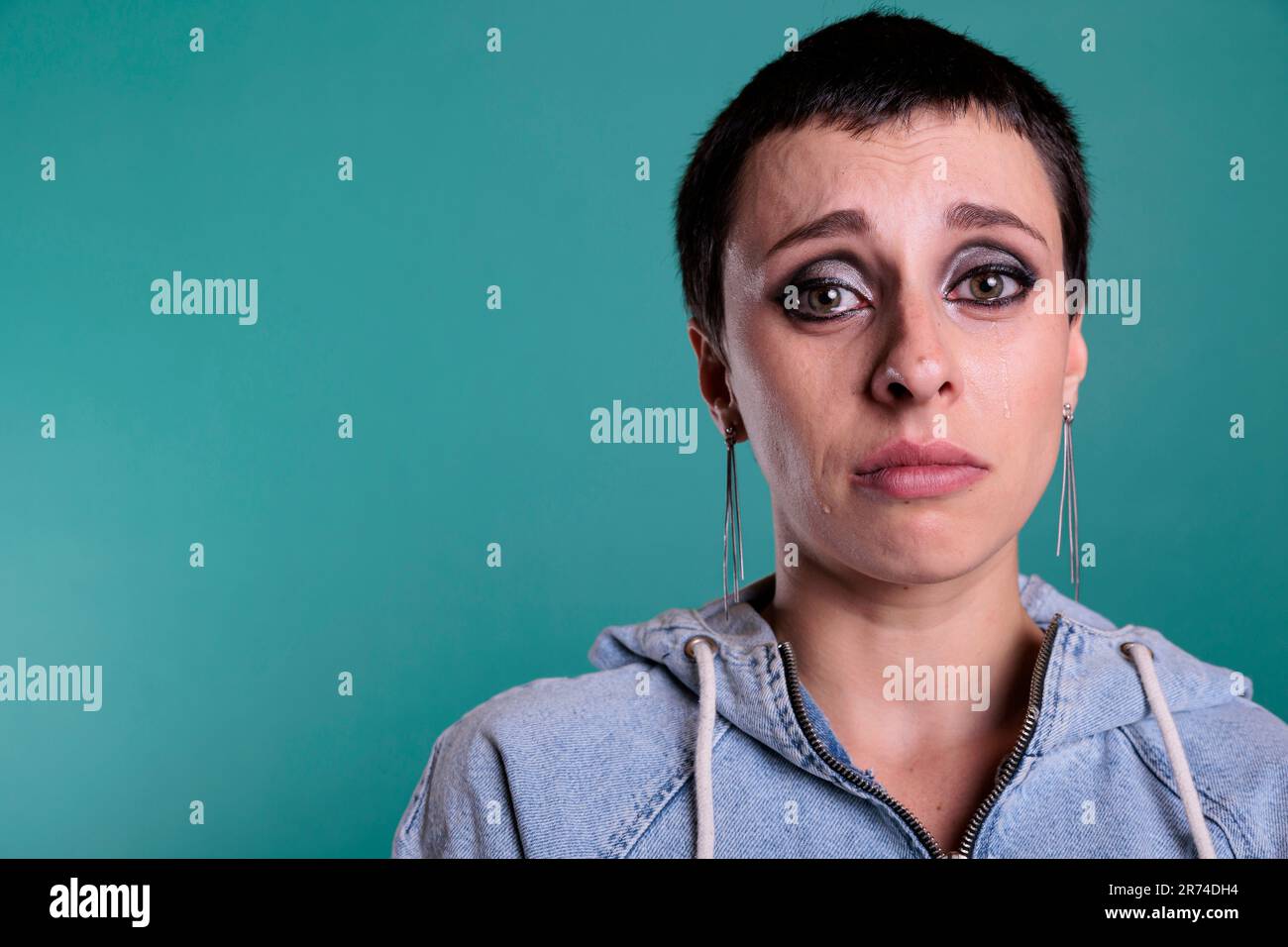 Portrait of depressed unhappy caucasian female looking at camera while ...