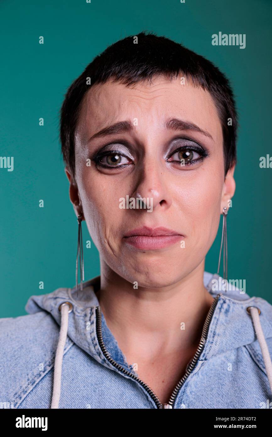 Upset sad woman crying after hearing tragic news during studio shot ...