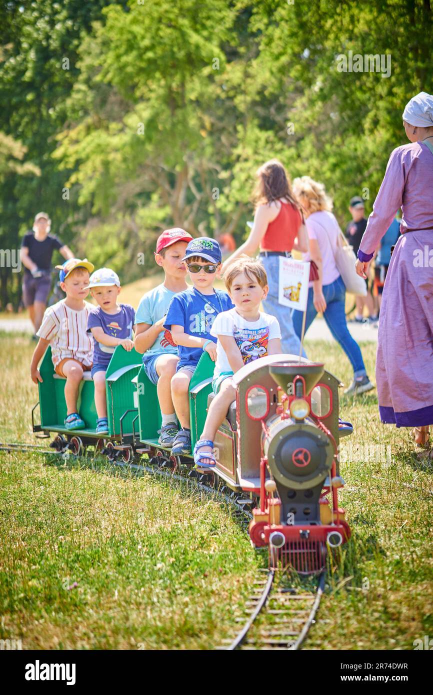 A group of happy children riding on a train in a park in Poland Stock ...