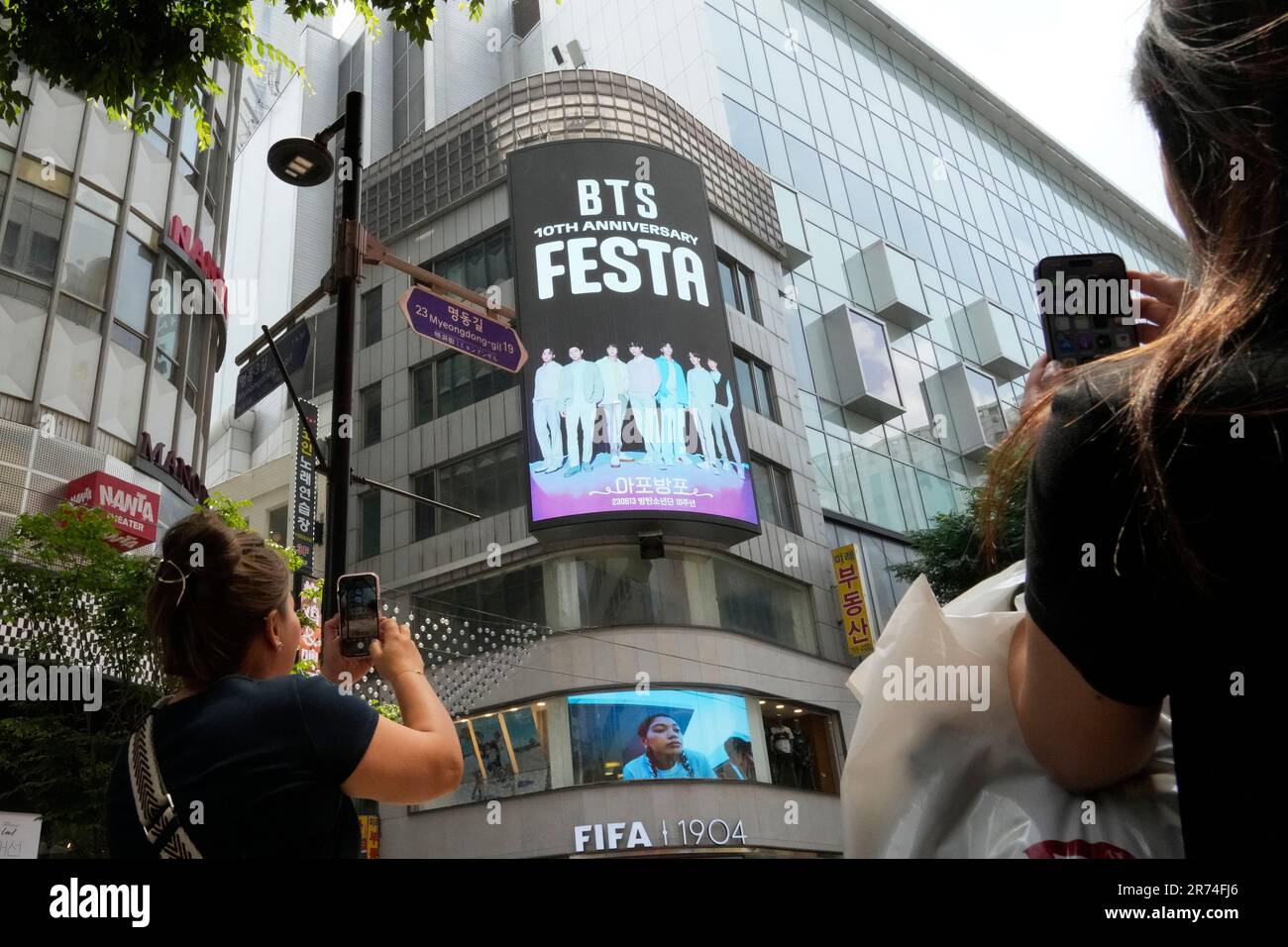 A screen shows an image of K-pop band BTS to celebrate its 10th debut ...