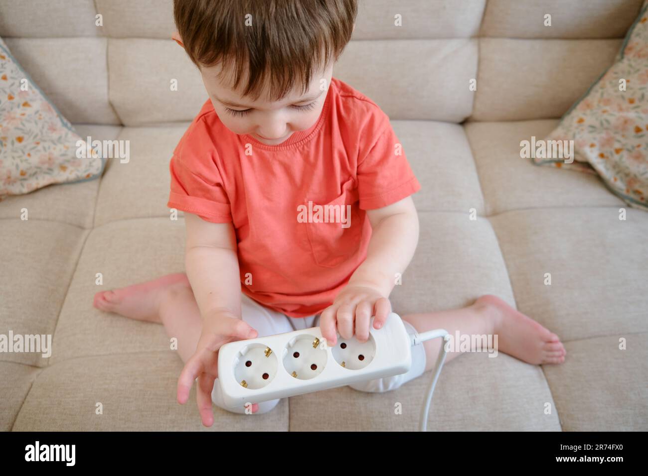 Boy put power plug into electrical outlet hi-res stock photography and ...