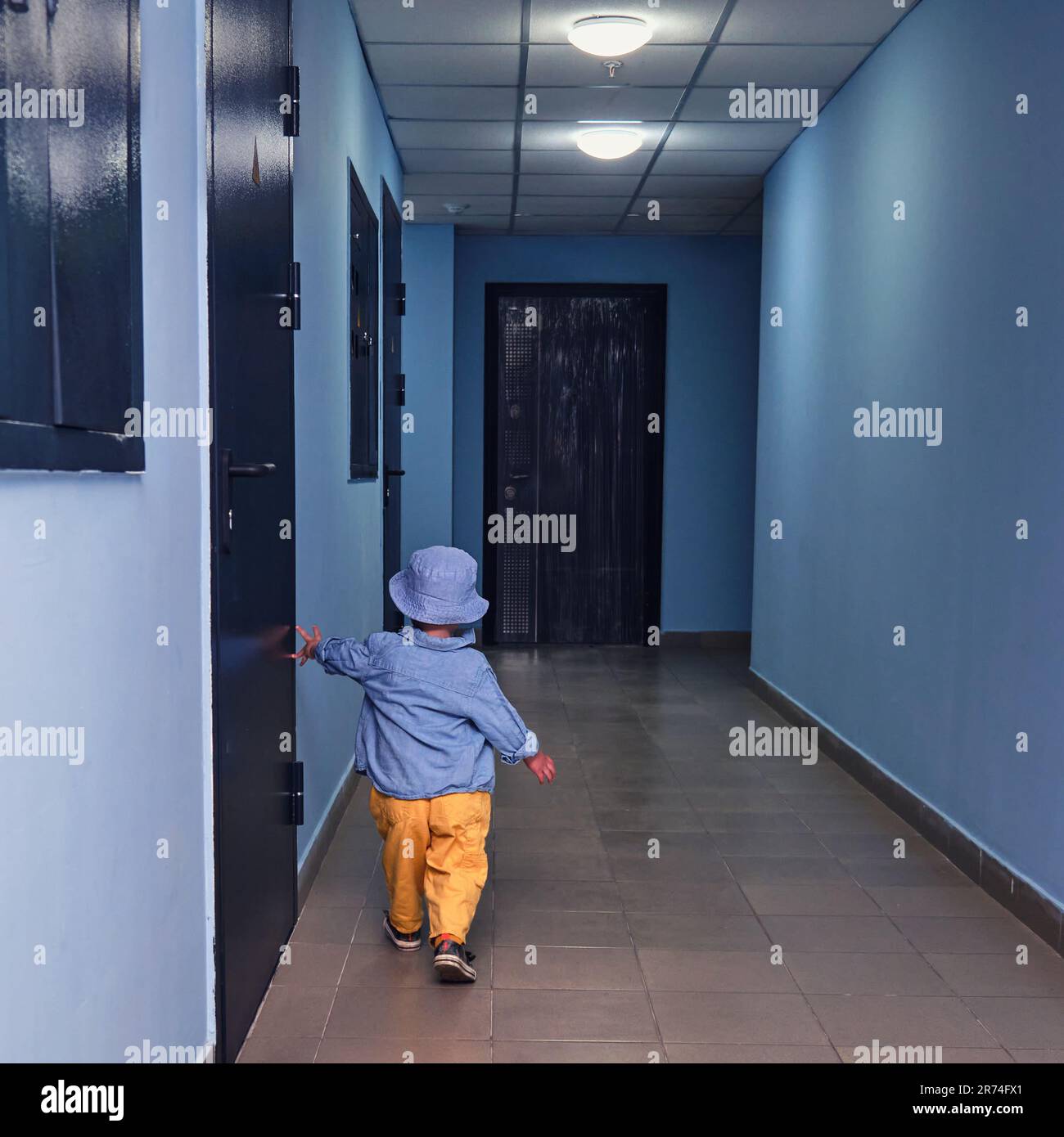 The toddler baby walks in the entrance hall on the floor near the ...