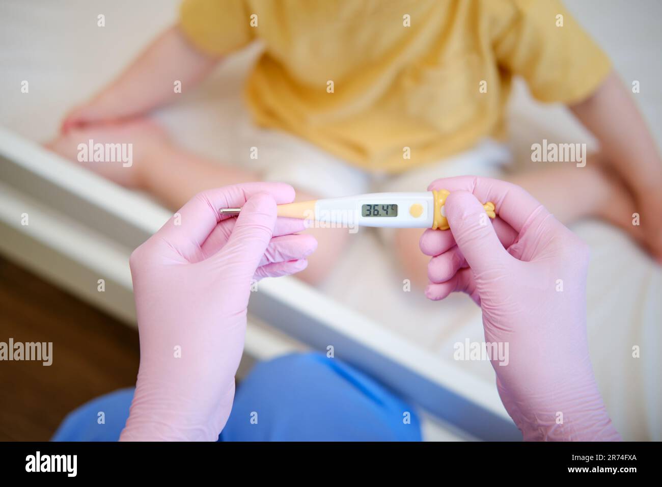 The pediatrician is measuring the infant's temperature with a medical ...