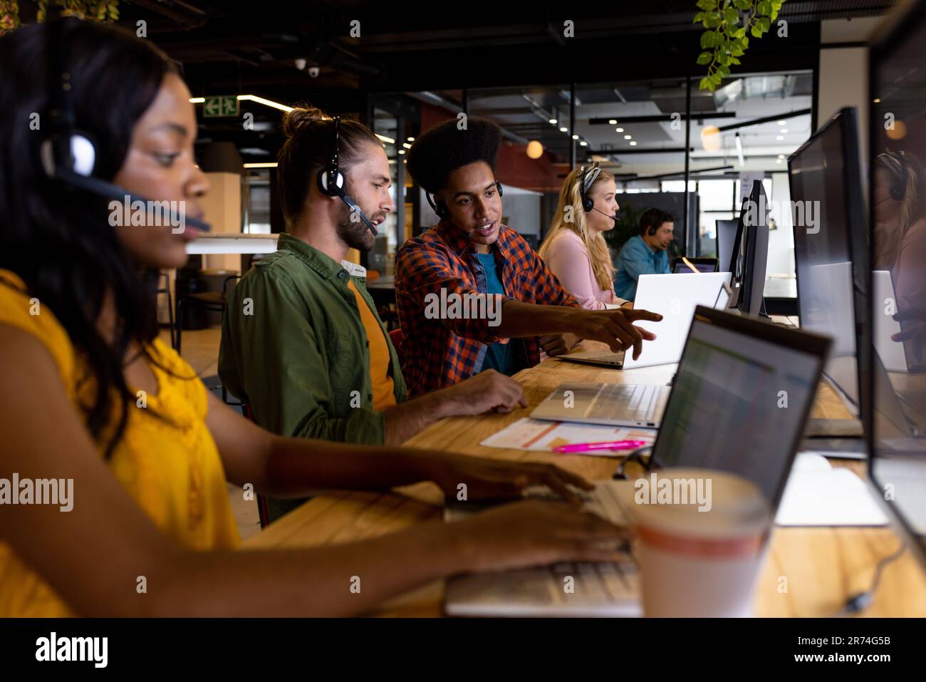 Diverse male and female creative colleagues working using phones ...