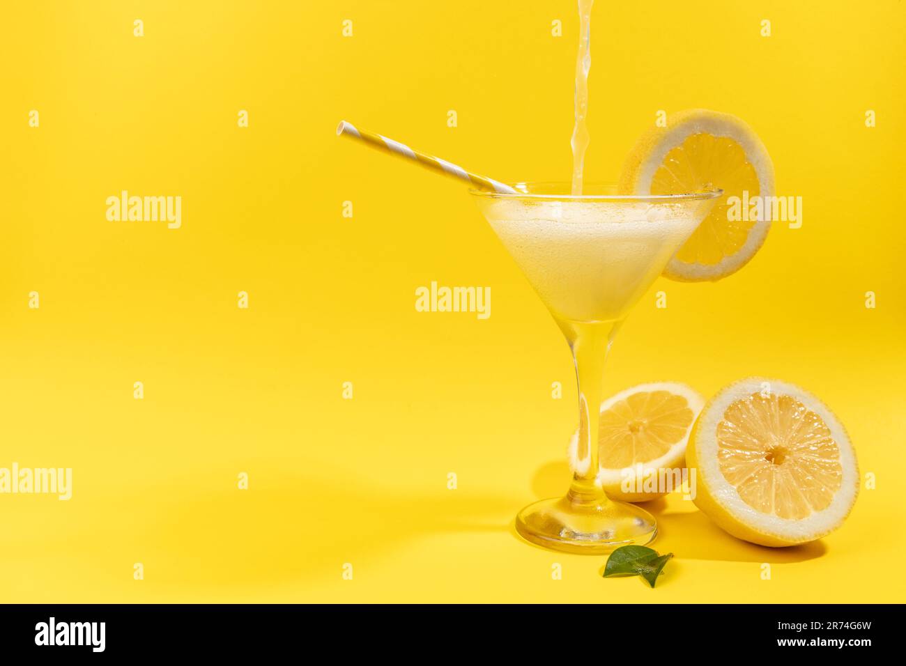 Fresh lemonade with lemon on yellow background Stock Photo - Alamy