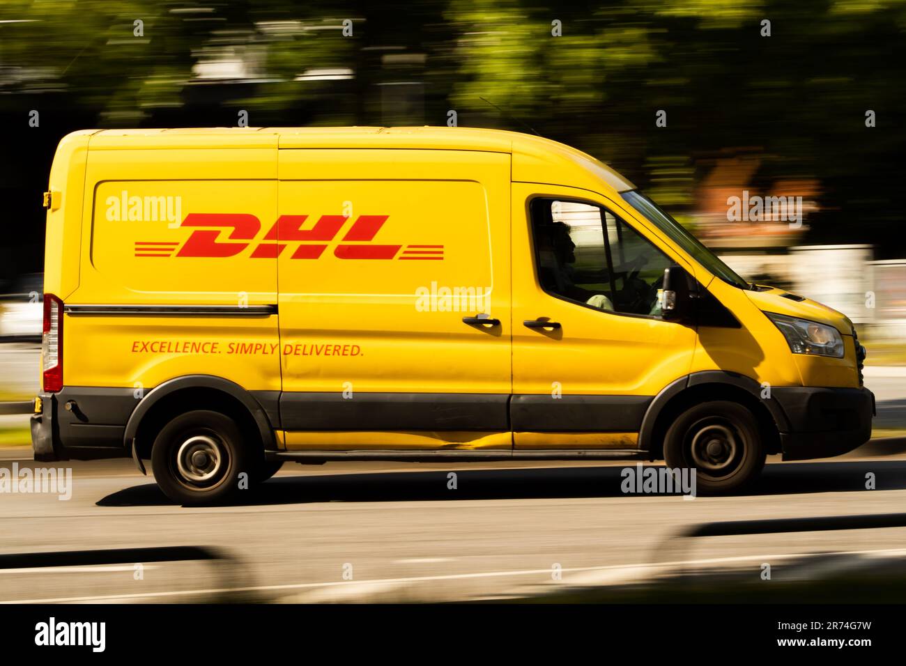 A yellow DHL transporter in a rush Stock Photo - Alamy