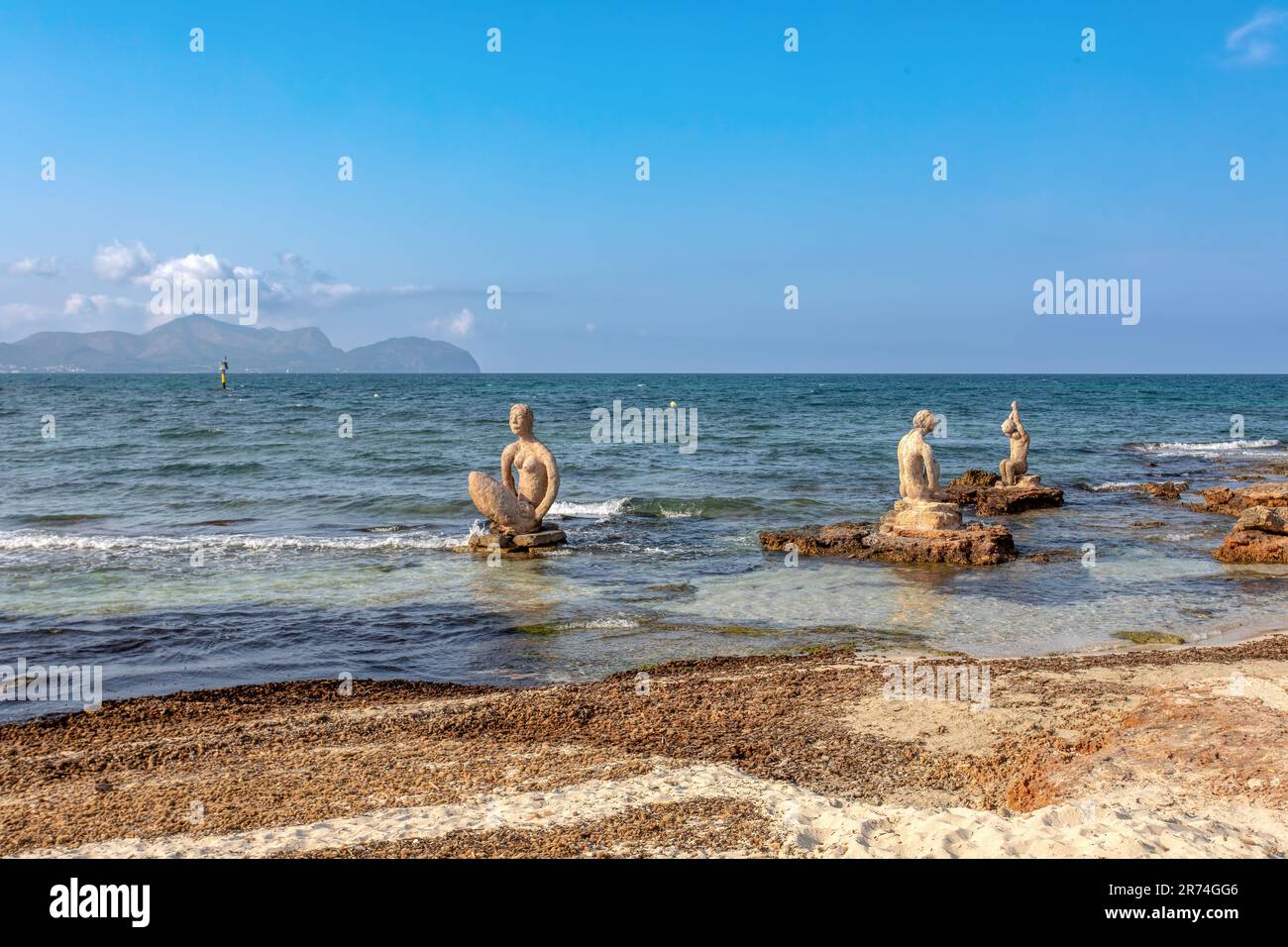 Group of sculptures, statues of people on beach in Can Picafort. Clear ...