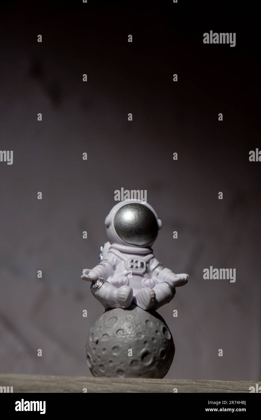 Plastic toy figure astronaut on moon concrete background Copy space ...