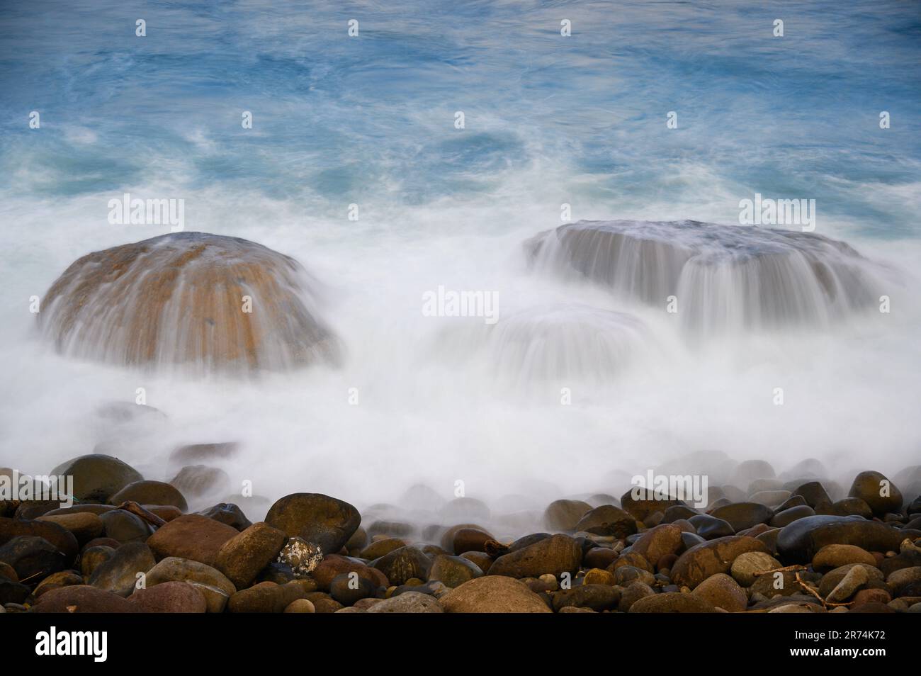 White waves flow slowly from the rocks into the sea. Slow exposure shot ...