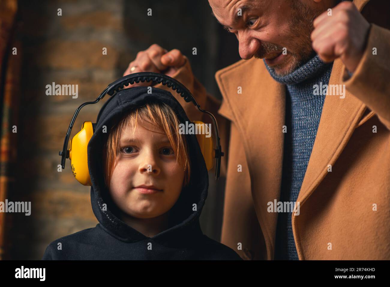 The father yells at the child. Young boy wearing headphones from noise ...