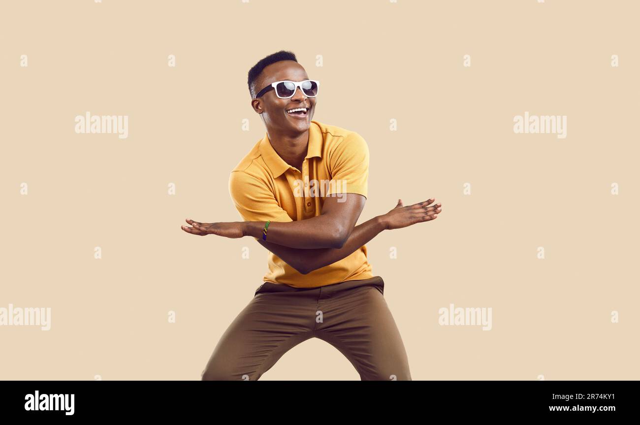 Positive cool dark-skinned man rejoices, has fun and dances isolated on ...