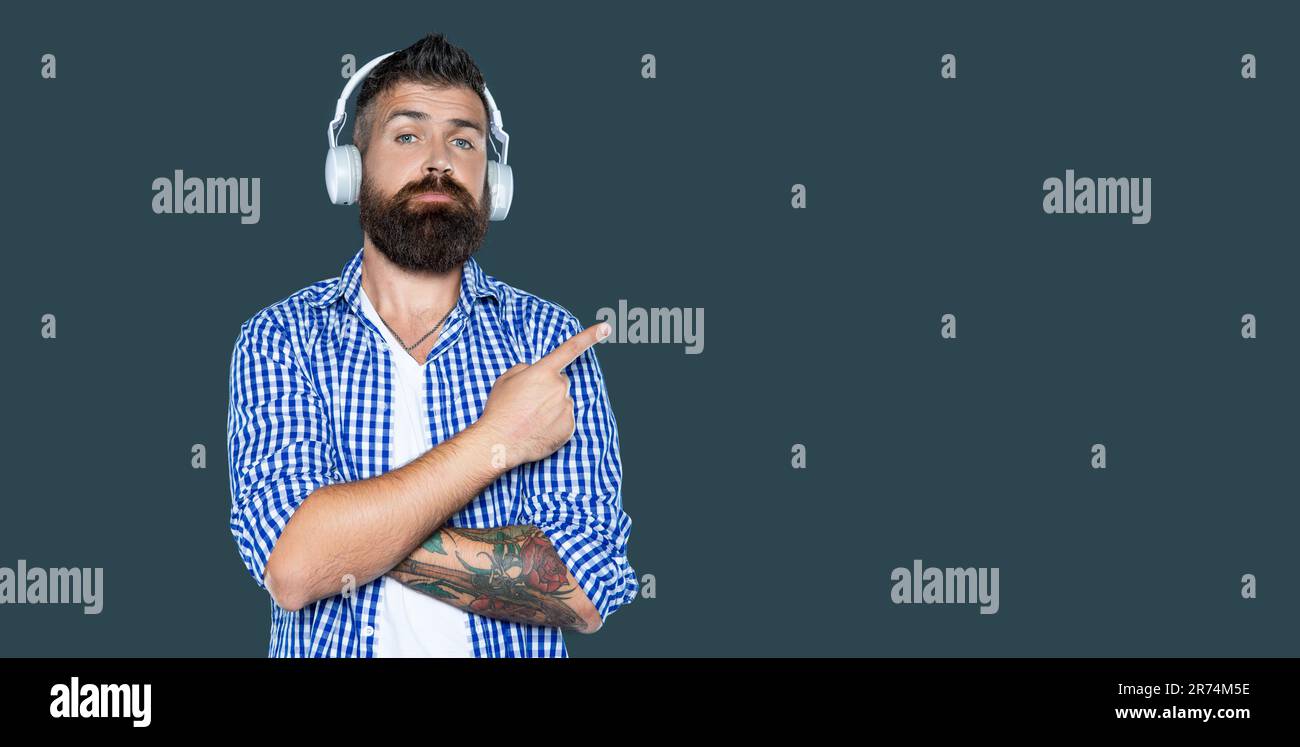 bearded man listen to music pointing finger on headphones Stock Photo ...