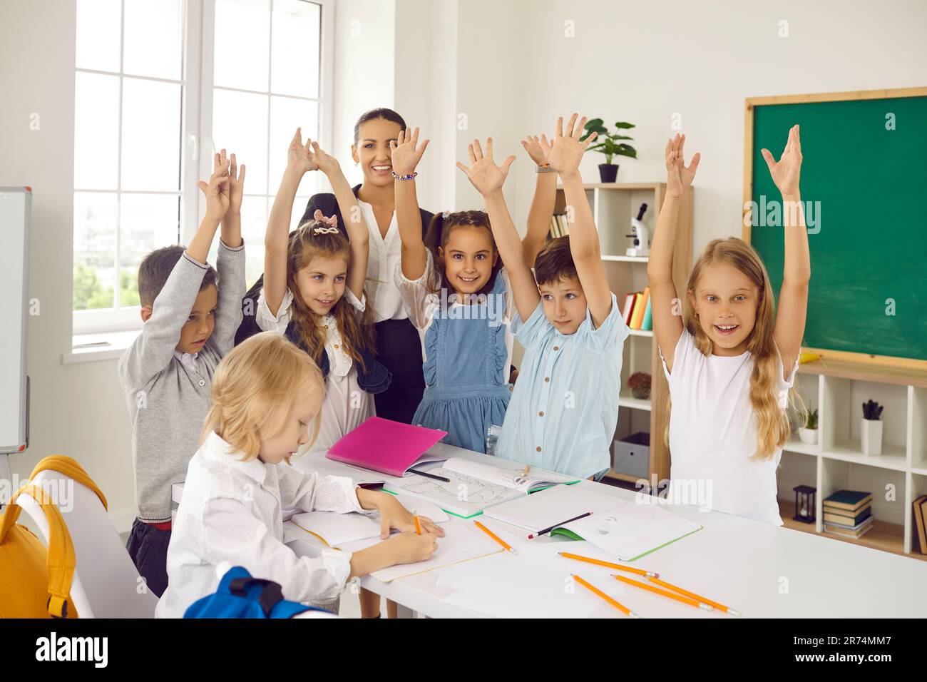 Happy, joyful school teacher and elementary students having fun in the ...