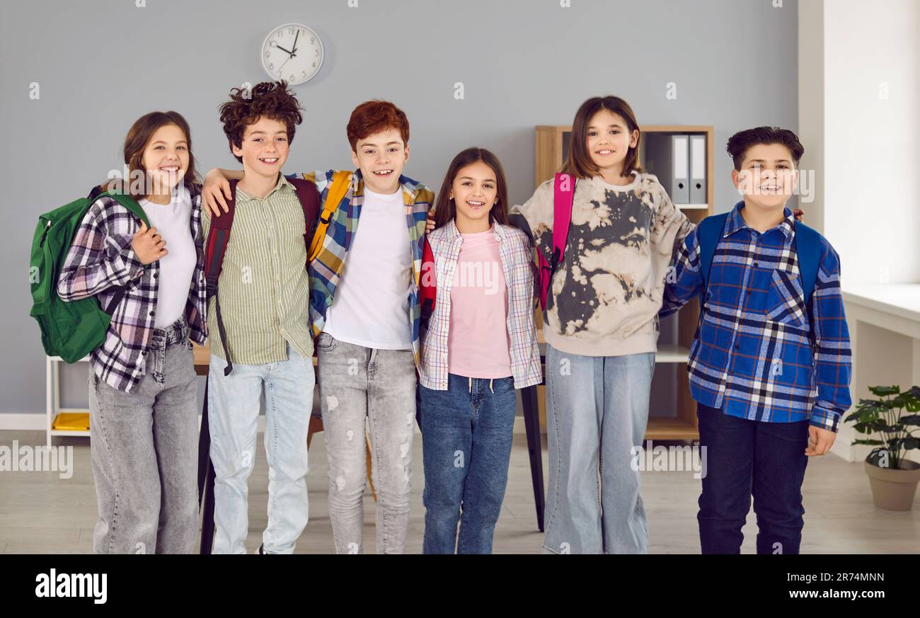 Group of happy junior school students standing in classroom Stock Photo ...