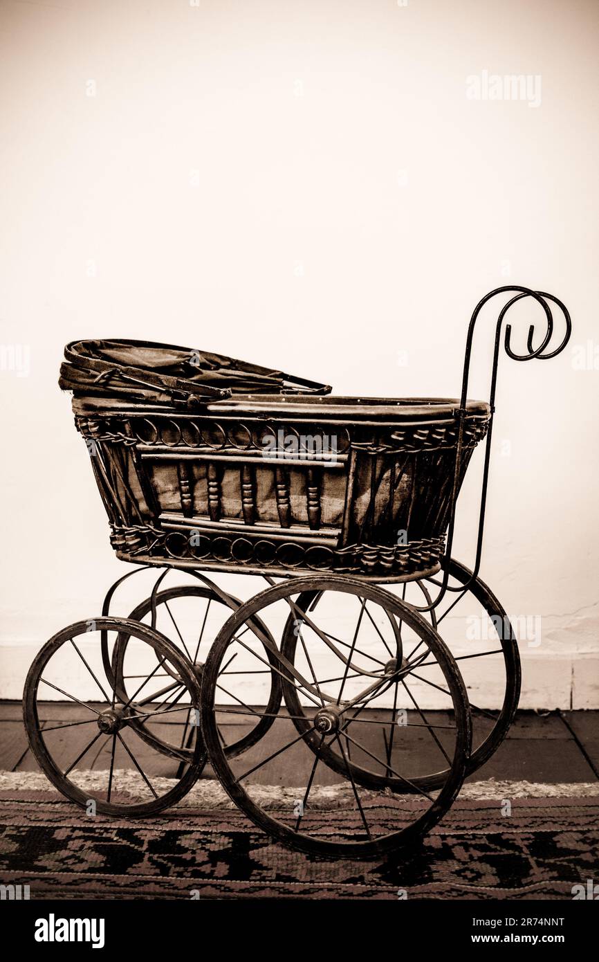 A vintage baby stroller against a white wall Stock Photo - Alamy