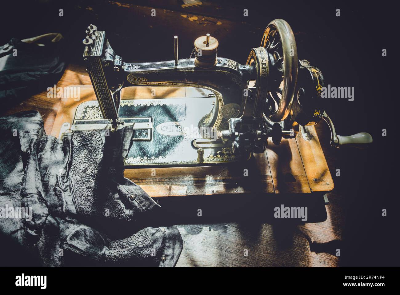 A vintage sewing machine with a completed project on its work surface ...