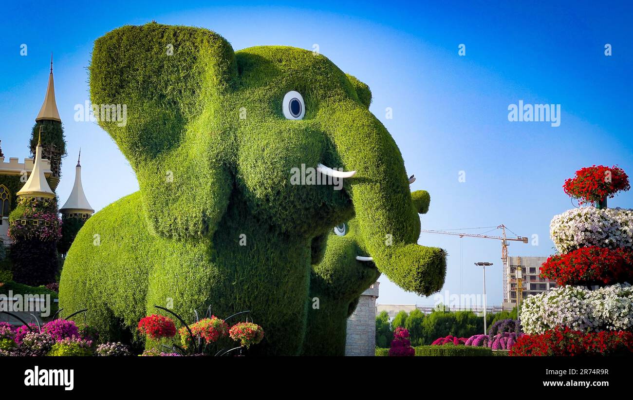 An elephant-shaped tree in a green garden surrounded by flowers Stock ...