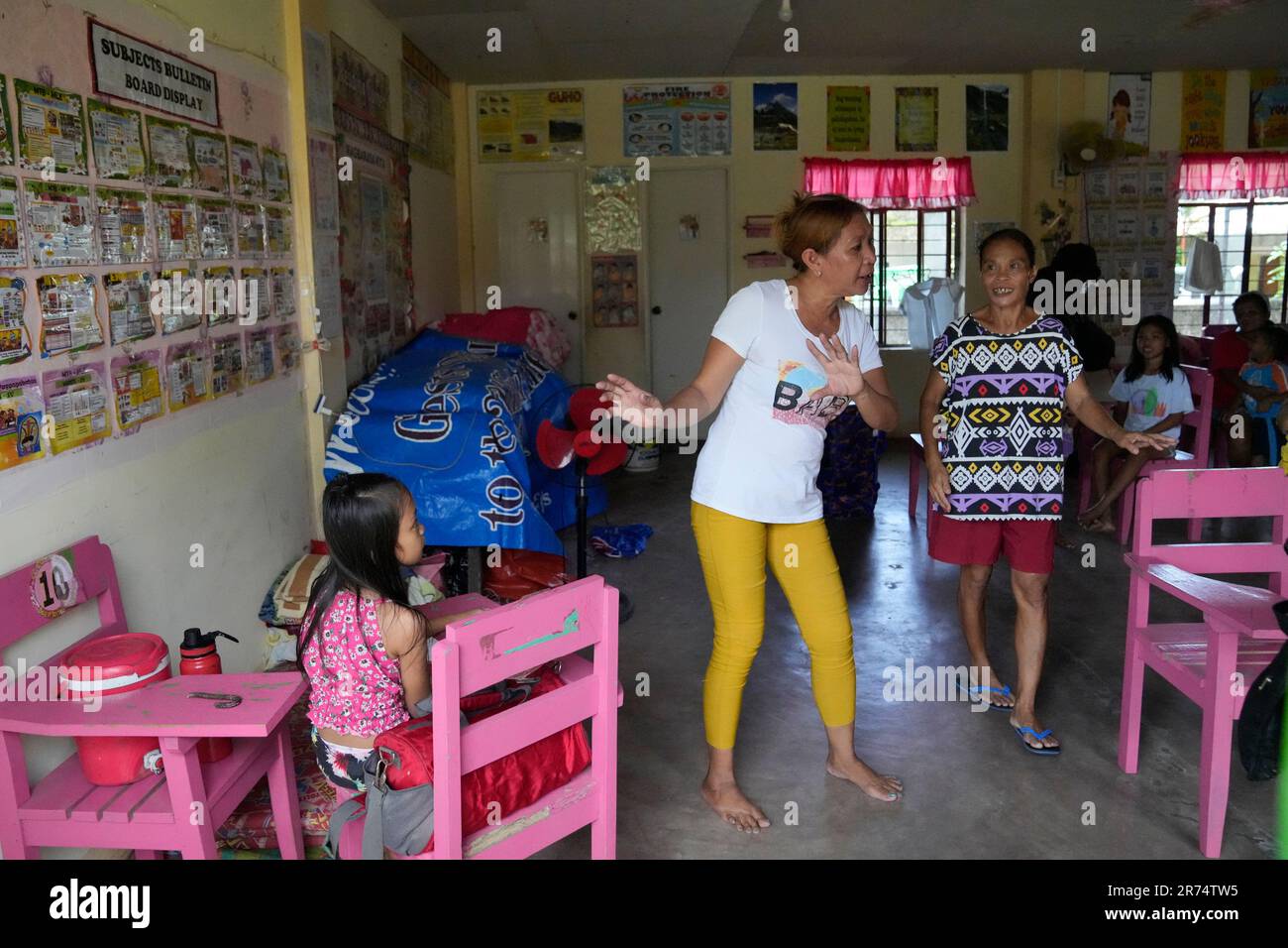Liza David Balbin, center, gestures inside a school converted into a ...