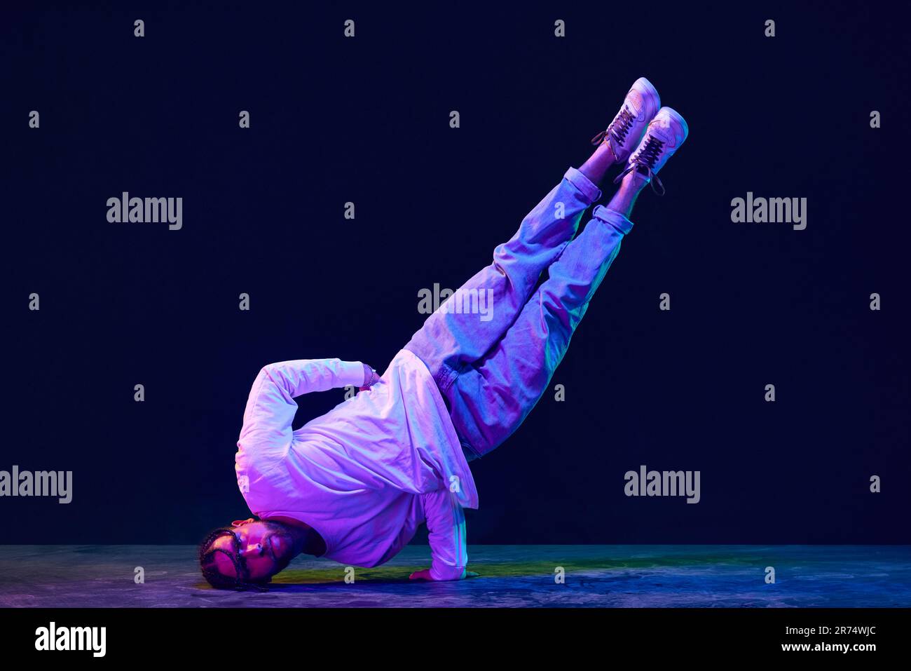 Young guy in sport style clothes dancing breakdance, hip-hop against ...