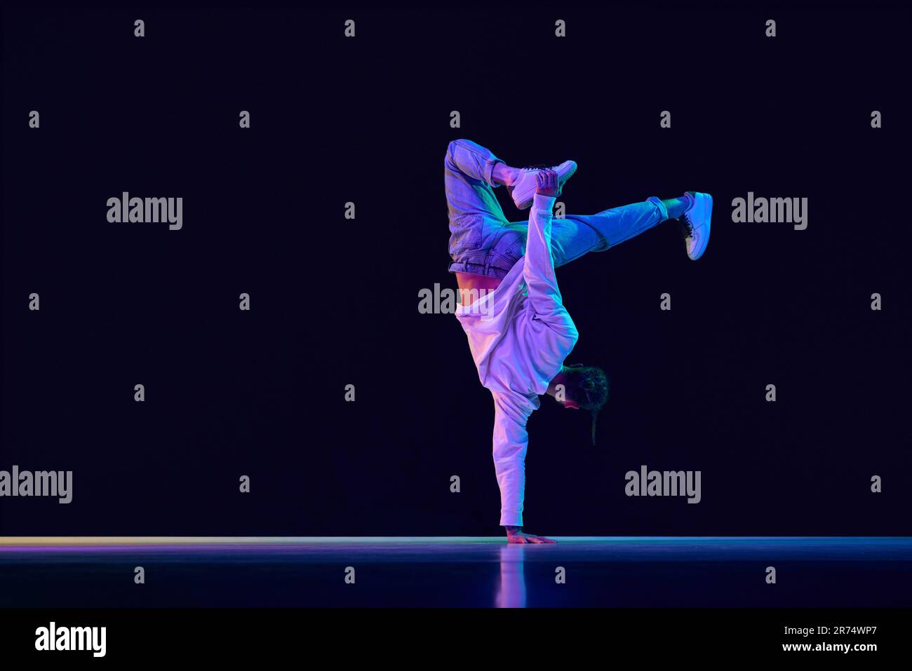 Youth culture. Young man in casual clothes making performance, dancing ...