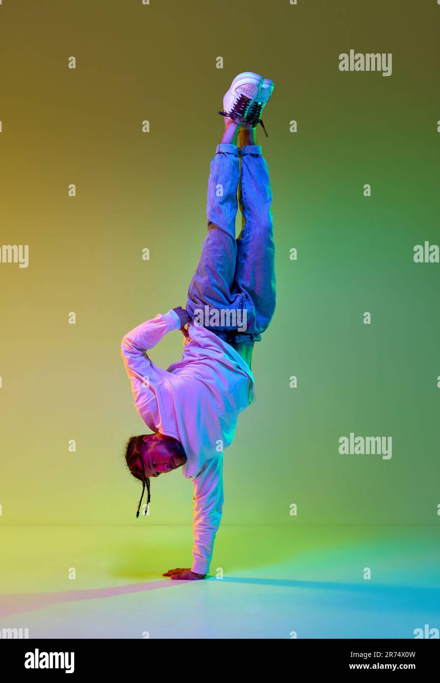 Young man with dreads hairstyle dancing hip-hop, breakdance against ...