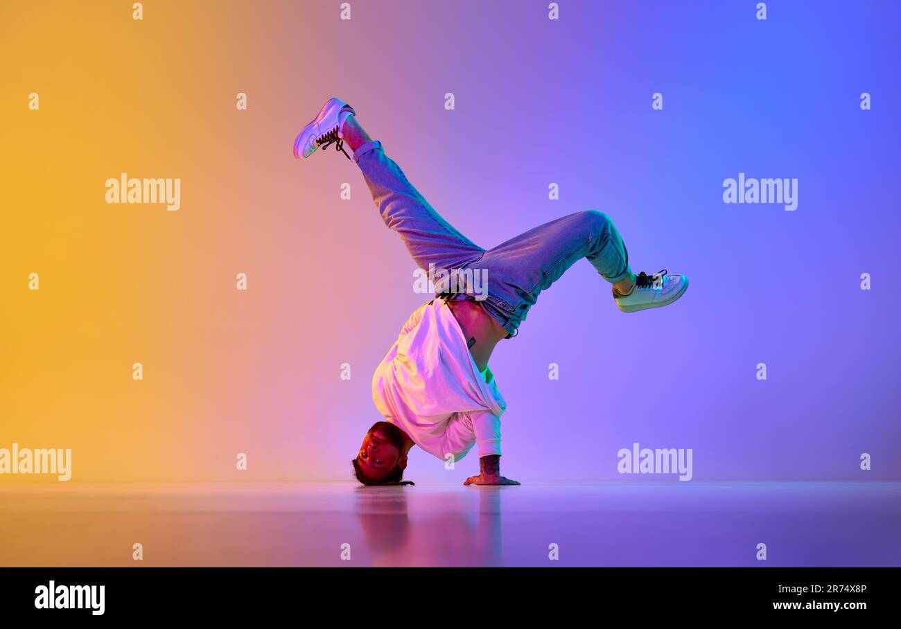 Creative young guy in casual clothes dancing hip-hop contemporary ...