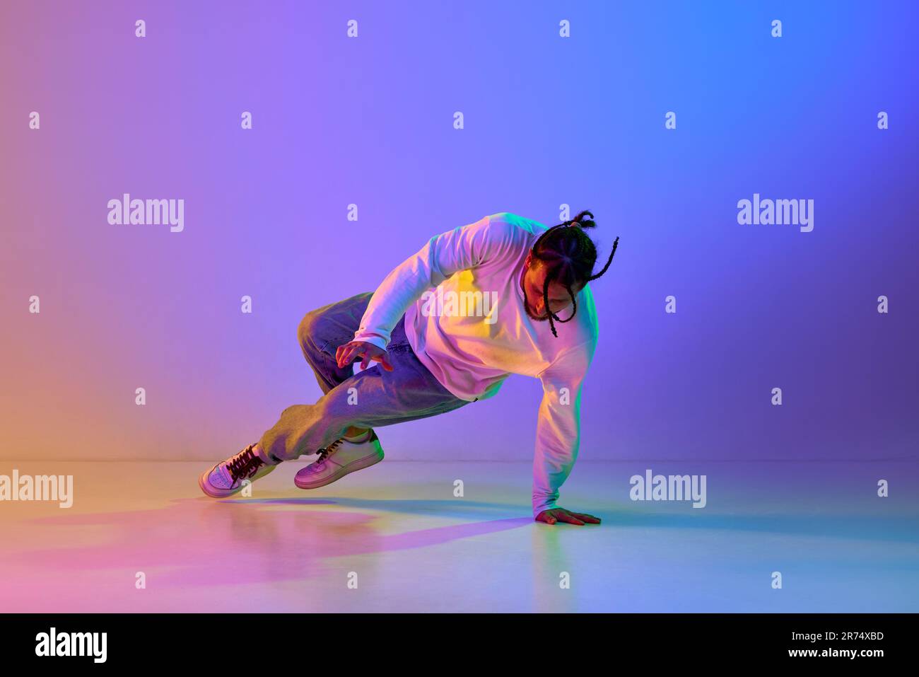 Young guy with dreads, in casual clothes dancing hip-hop, breakdance ...