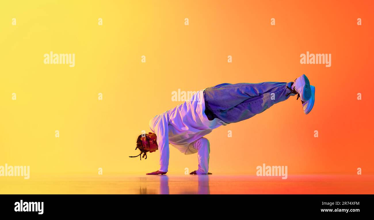 Standing on hands. Young guy making performance, dancing breakdance ...