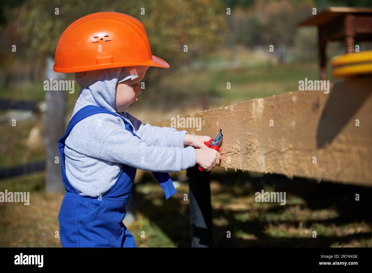 Boy toddler playing as builder on construction site. Child carpenter in ...