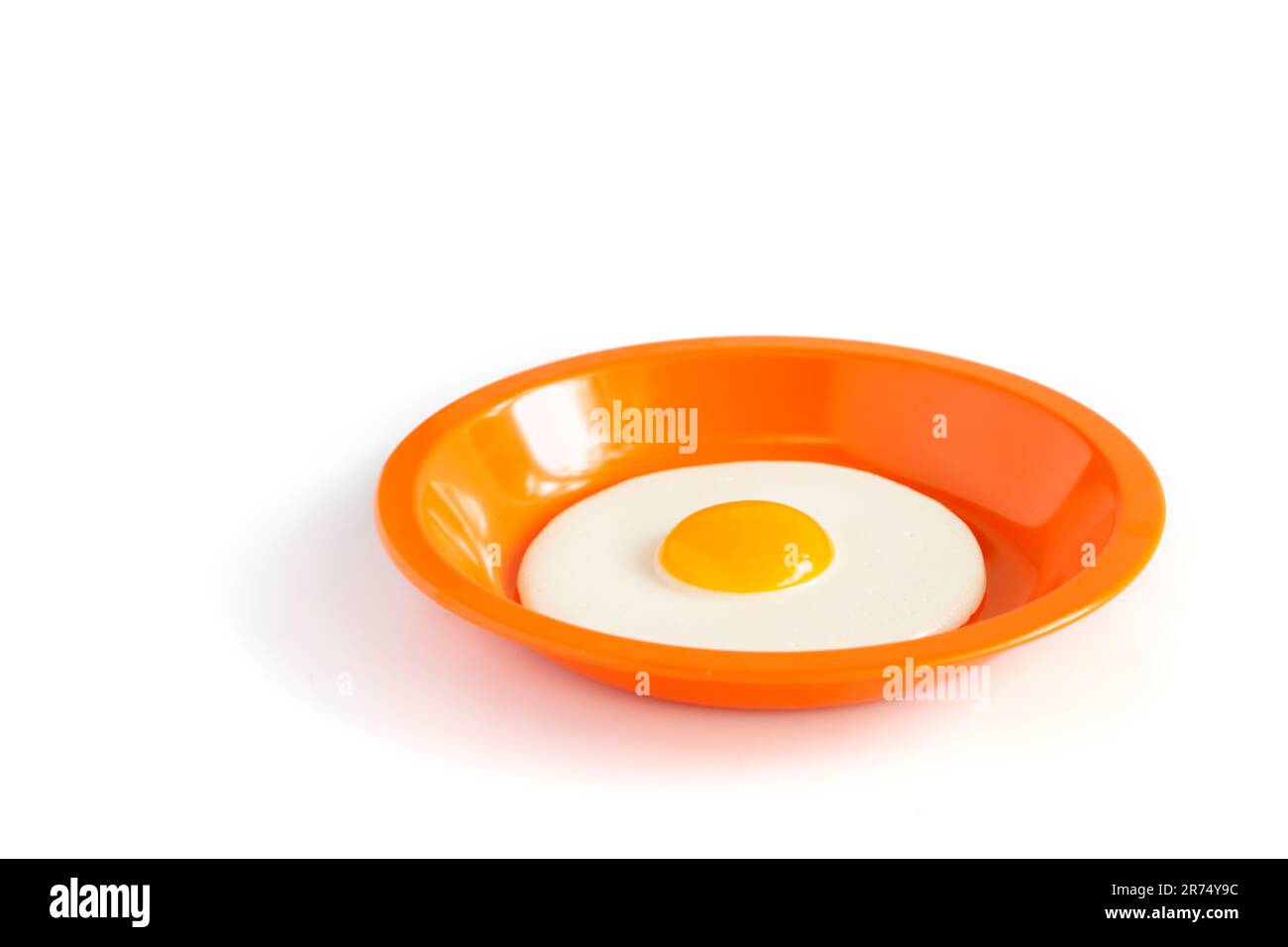 fried egg and round shape in a orange color dish, isolated on white ...