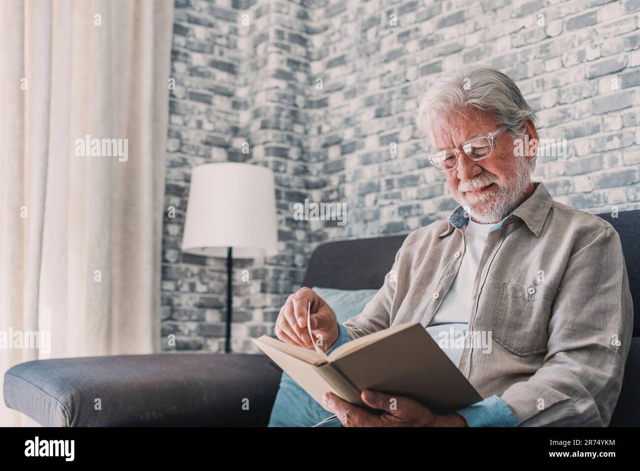 Headshot portrait close up of old happy and relaxed man sitting reading ...
